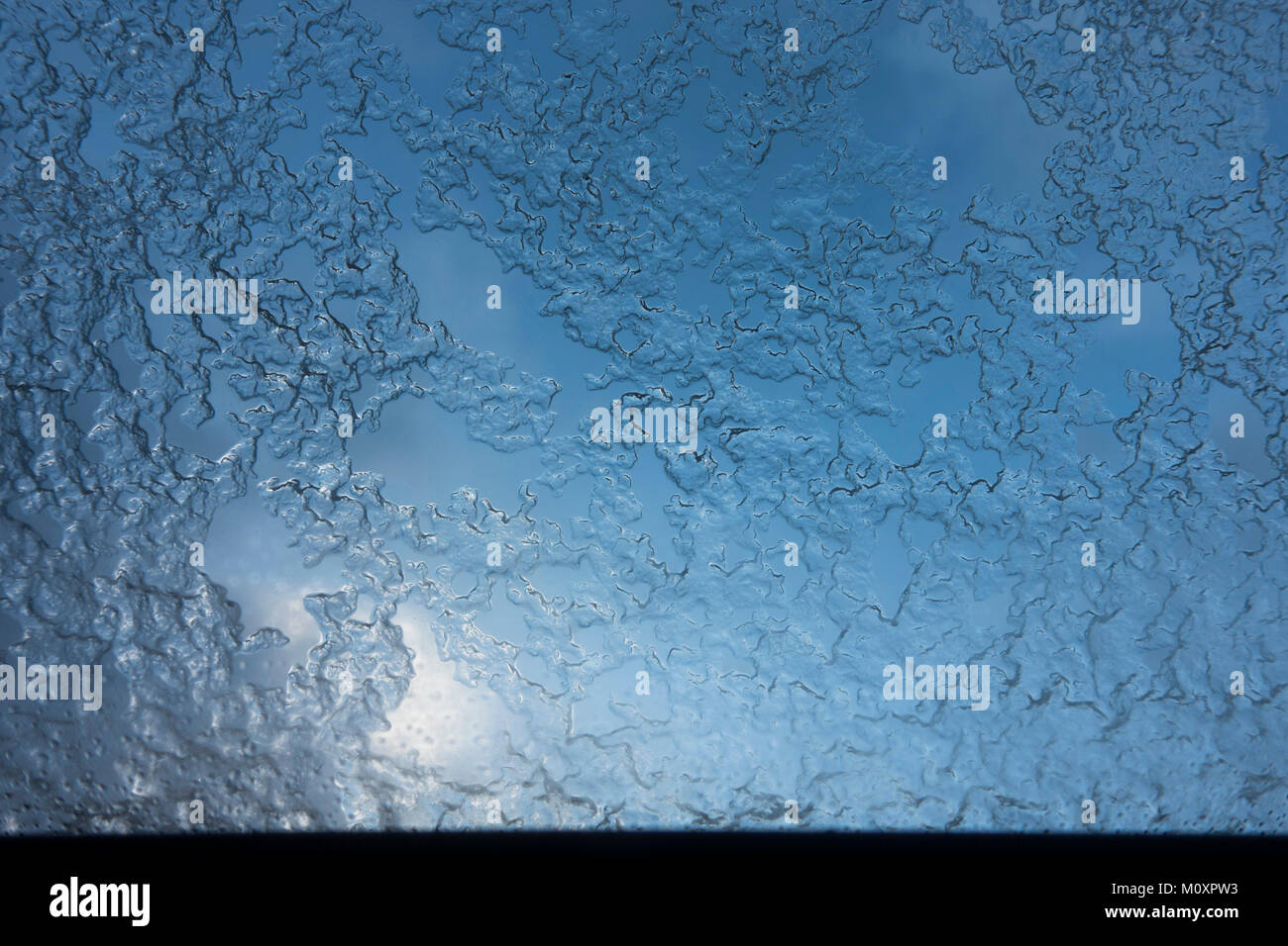 Hail and ice graupel, on glass of rooftop window after hailstorm ...