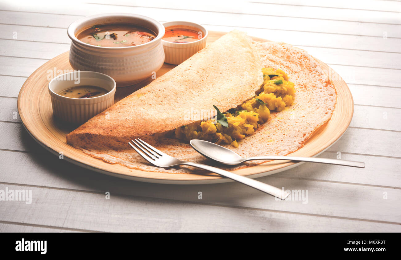 Masala dosa with chutney and sambar and potato sabzi. Cone, triangle or ...