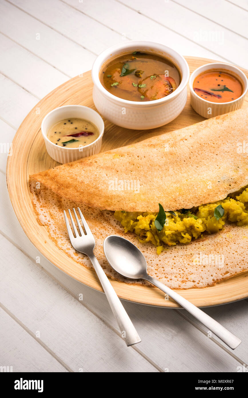 Masala dosa with chutney and sambar and potato sabzi. Cone, triangle or ...