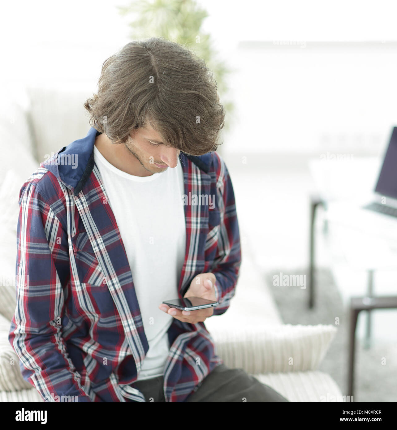modern guy looking at screen smartphone at home Stock Photo - Alamy