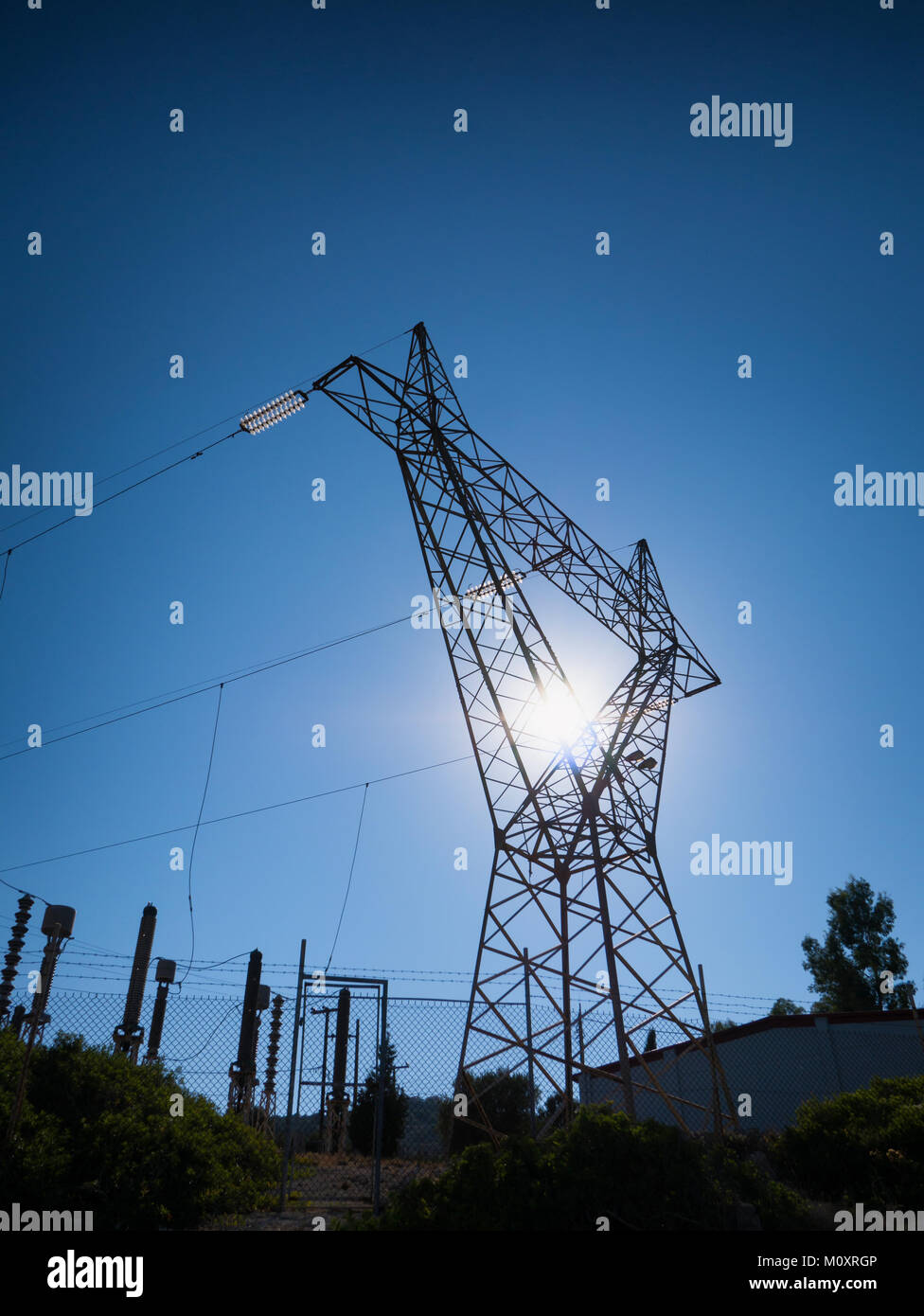 High voltage pole against the sun in a sunny day Stock Photo - Alamy