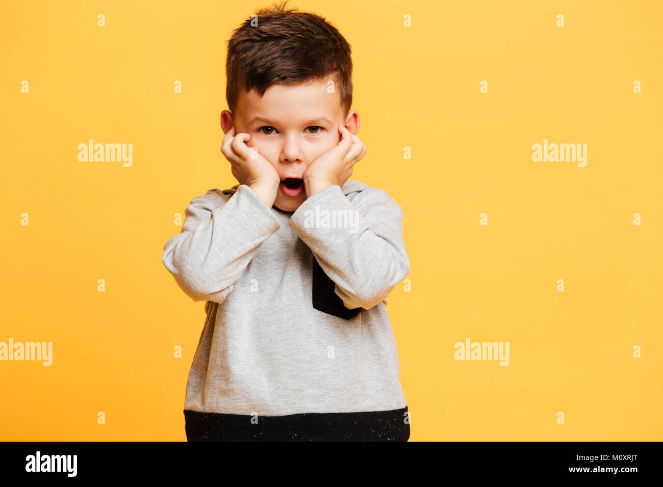 Image of shocked little boy child standing isolated over yellow ...