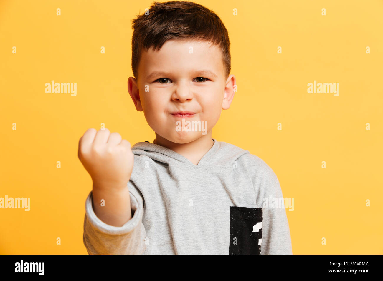 Image of angry little boy child standing isolated over yellow ...
