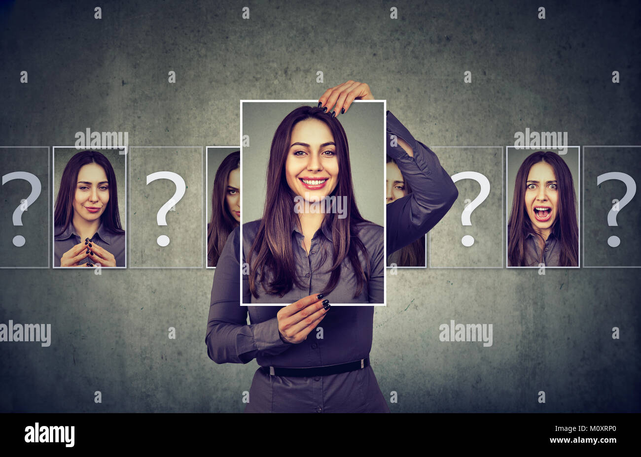 Young woman having split personality while posing with photos of ...