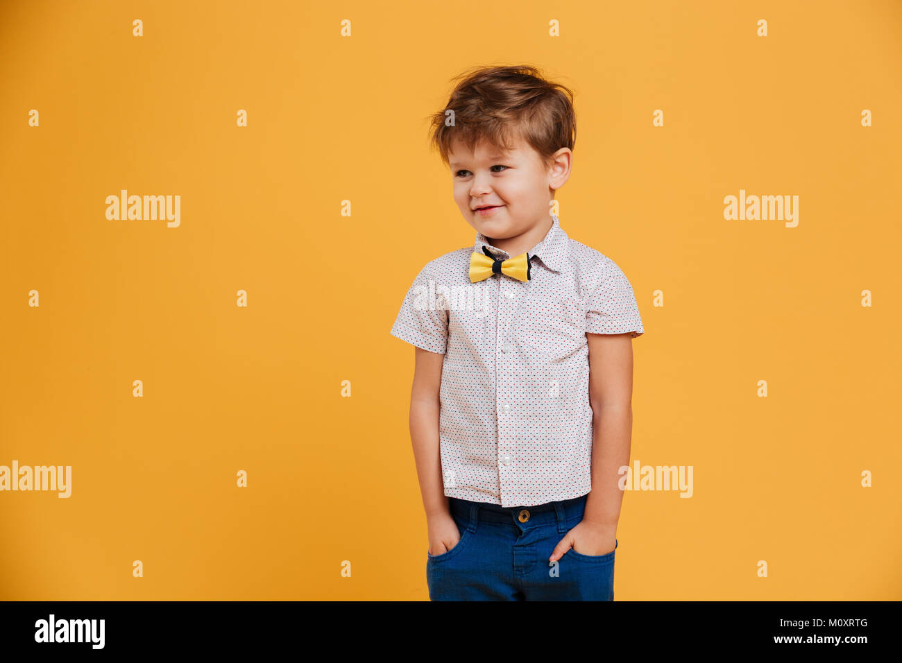 Image of happy little boy child standing isolated over yellow ...