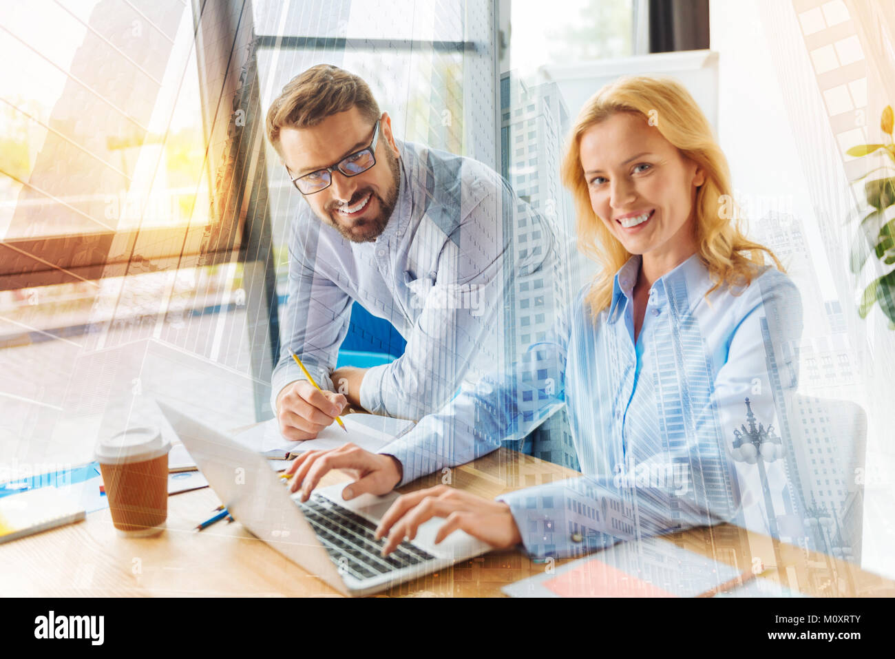 Portrait of cheerful colleagues during working process Stock Photo - Alamy