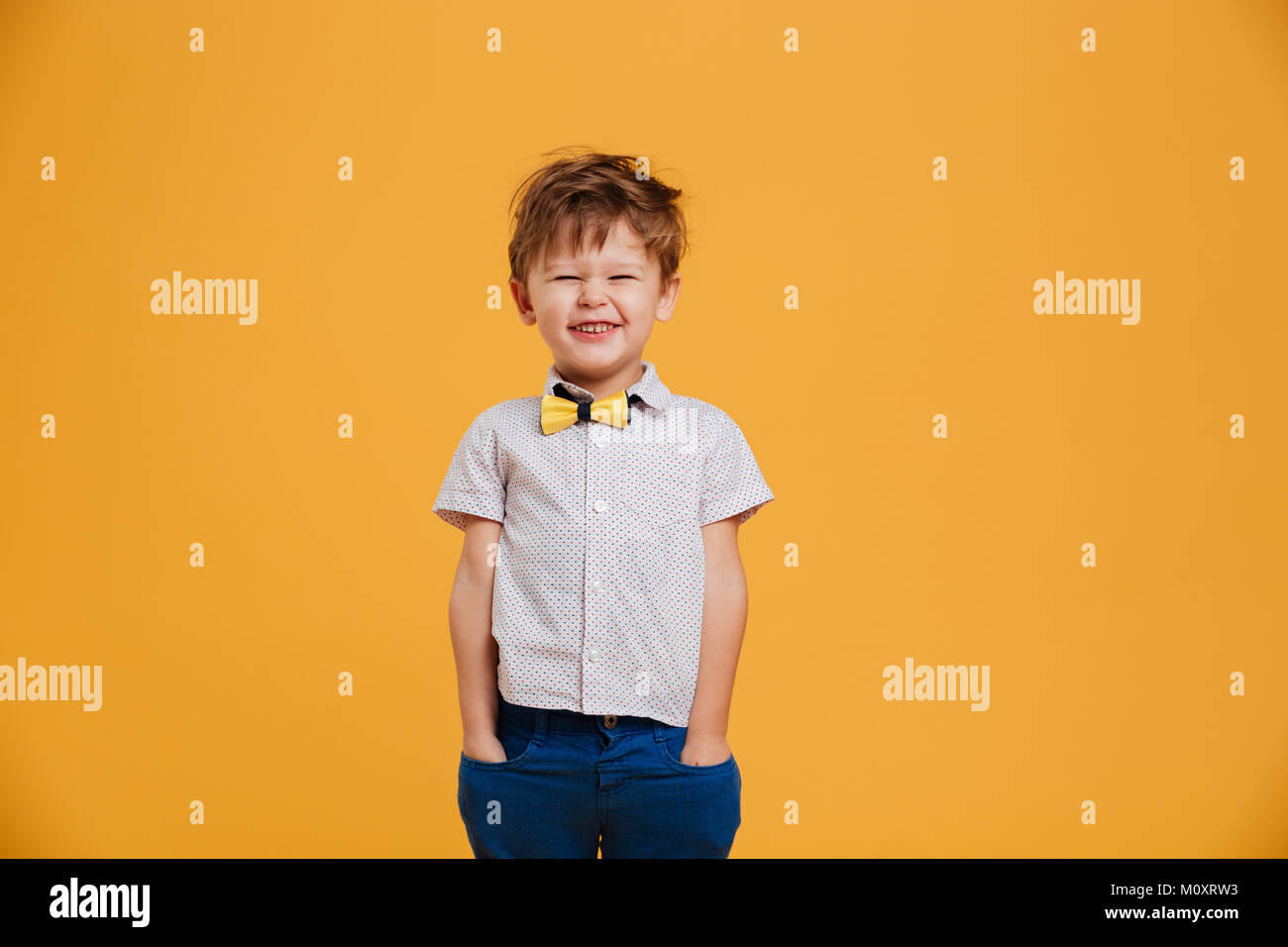 Photo of cheerful little boy child standing isolated over yellow ...