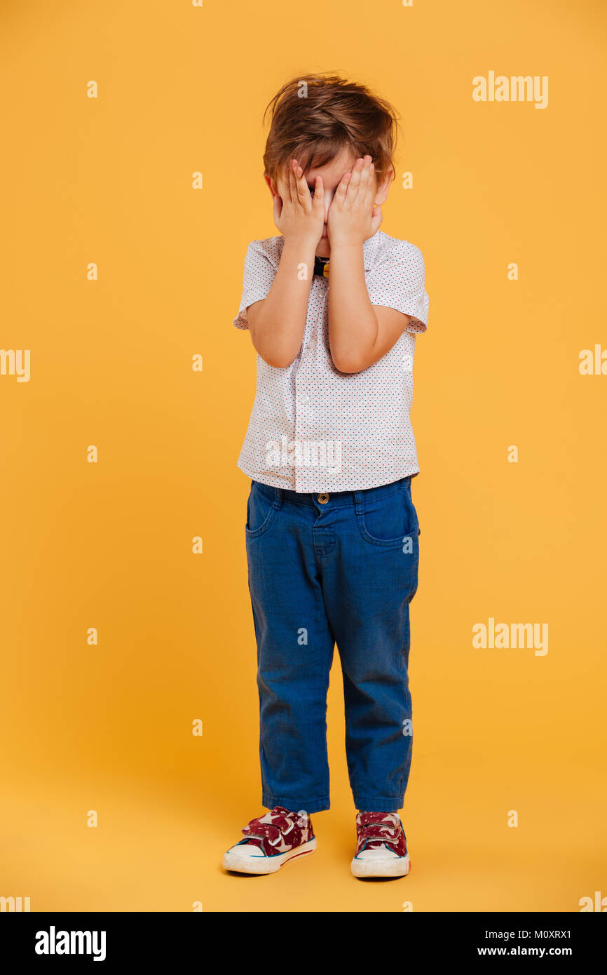 Image of little boy child standing isolated over yellow background ...