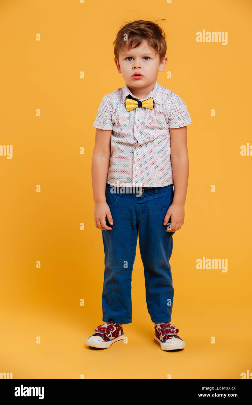 Picture of serious confused little boy child standing isolated over ...