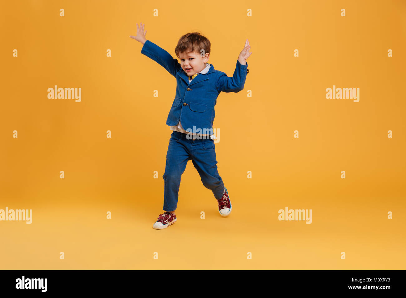 Picture of funny little boy child standing isolated over yellow ...