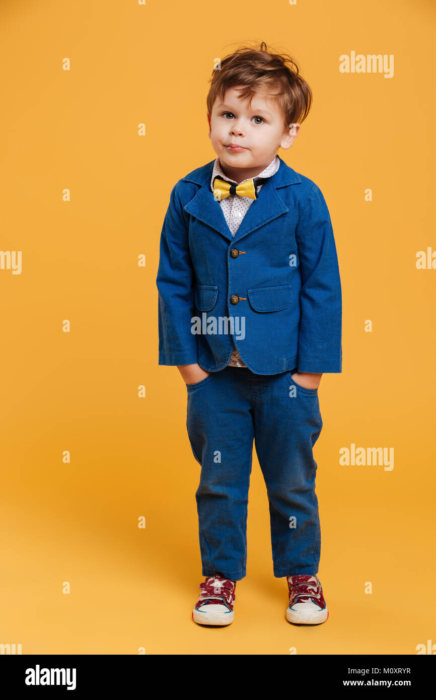 Image of little confused boy child standing isolated over yellow ...
