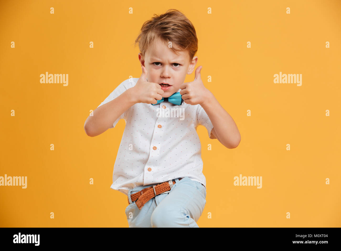 Photo of angry little boy child standing isolated over yellow ...