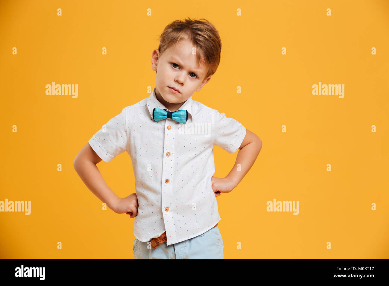 Photo of angry little boy child standing isolated over yellow ...