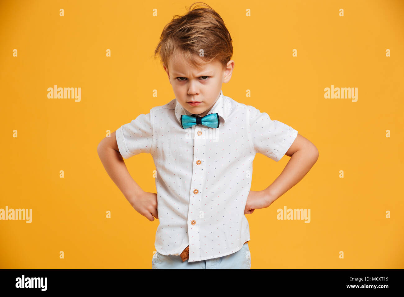 Image of angry little boy child standing isolated over yellow ...