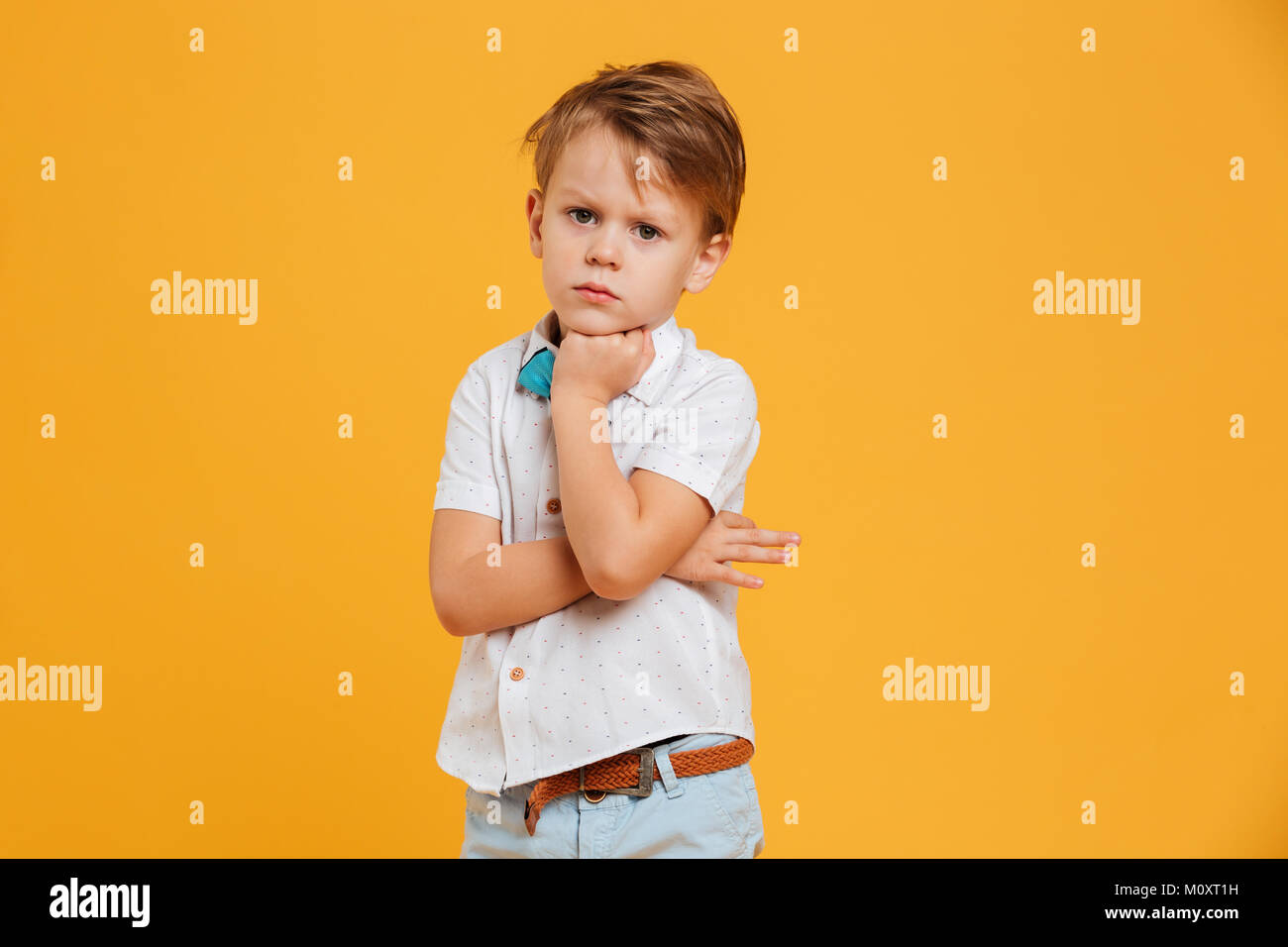 Picture of serious concentrated little boy child standing isolated over ...