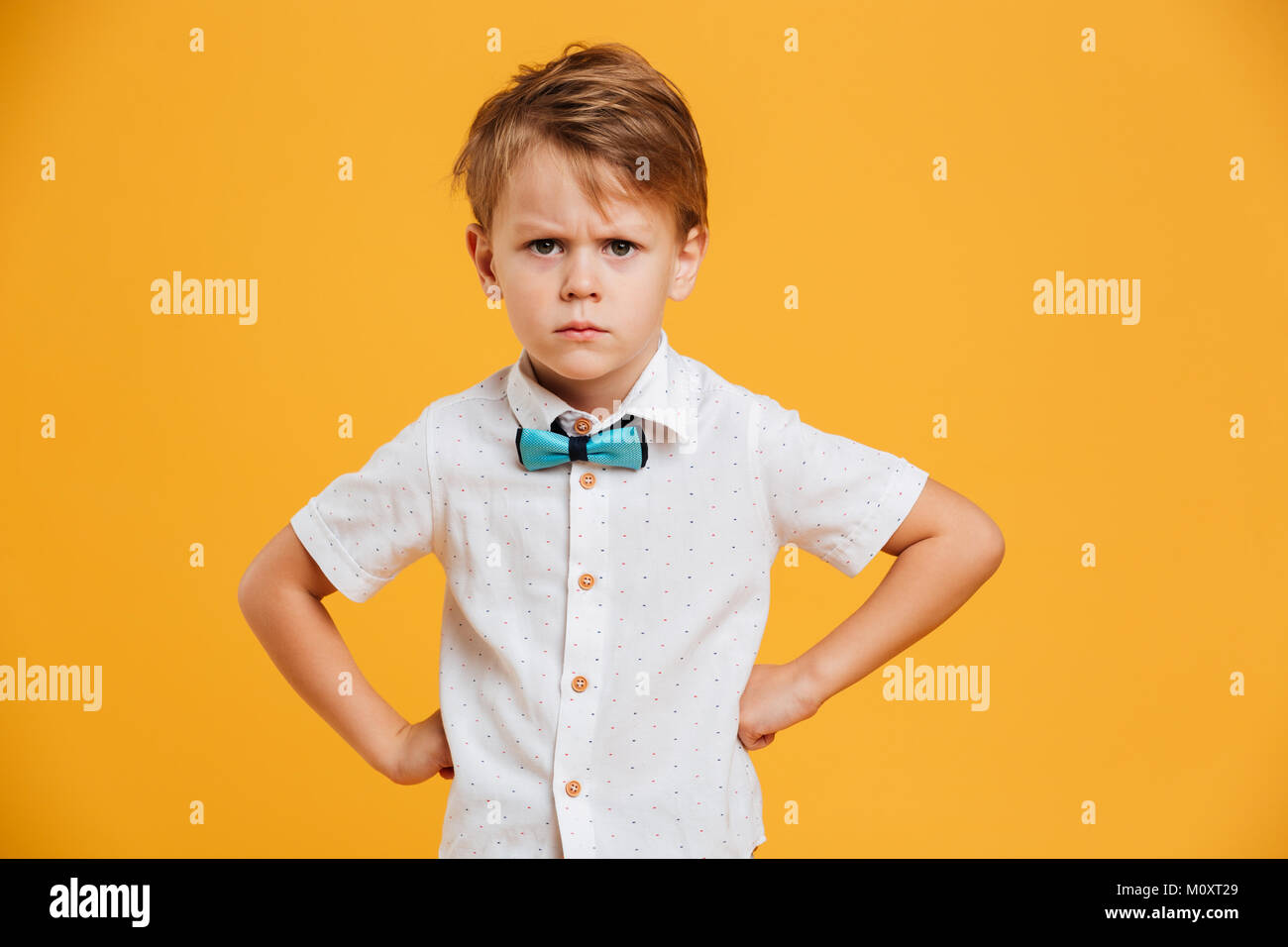 Photo of angry little boy child standing isolated over yellow ...