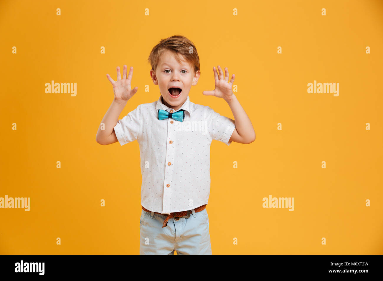 Photo of shocked little boy child standing isolated over yellow ...