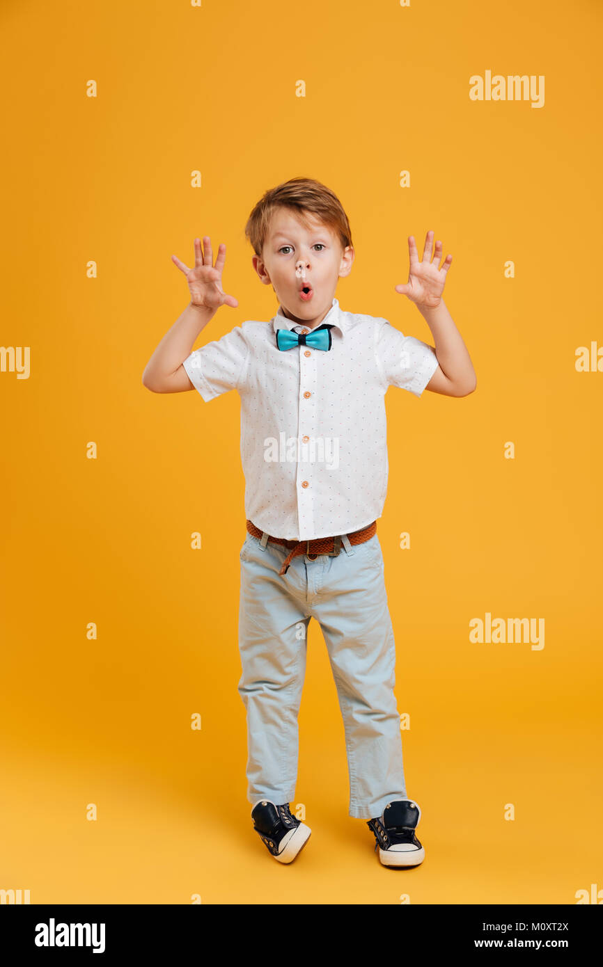 Photo of shocked little boy child standing isolated over yellow ...