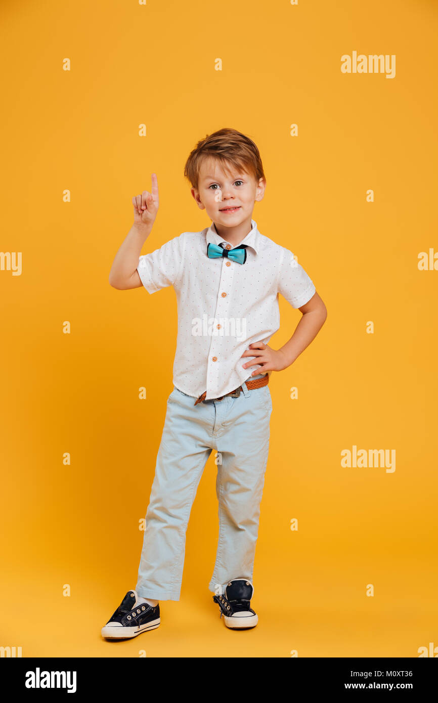Picture of excited little boy child standing isolated over yellow ...