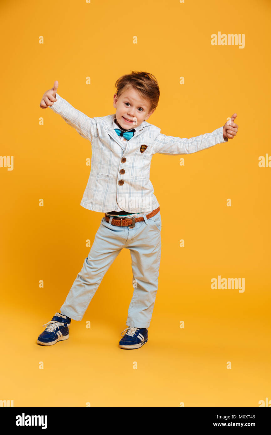 Image of happy little boy child standing isolated over yellow ...