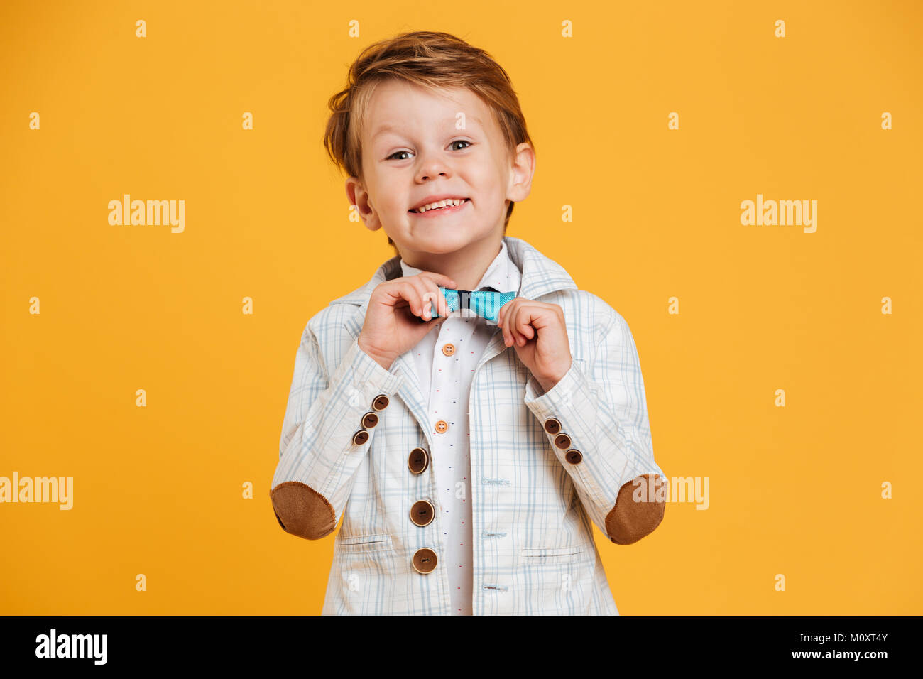 Photo of excited smiling little boy child standing isolated over yellow ...