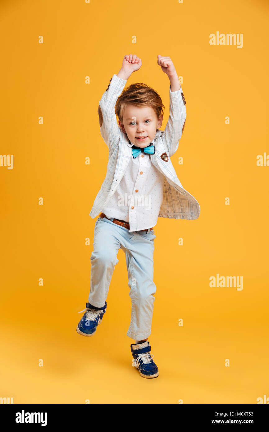 Picture of little boy child standing isolated over yellow background ...