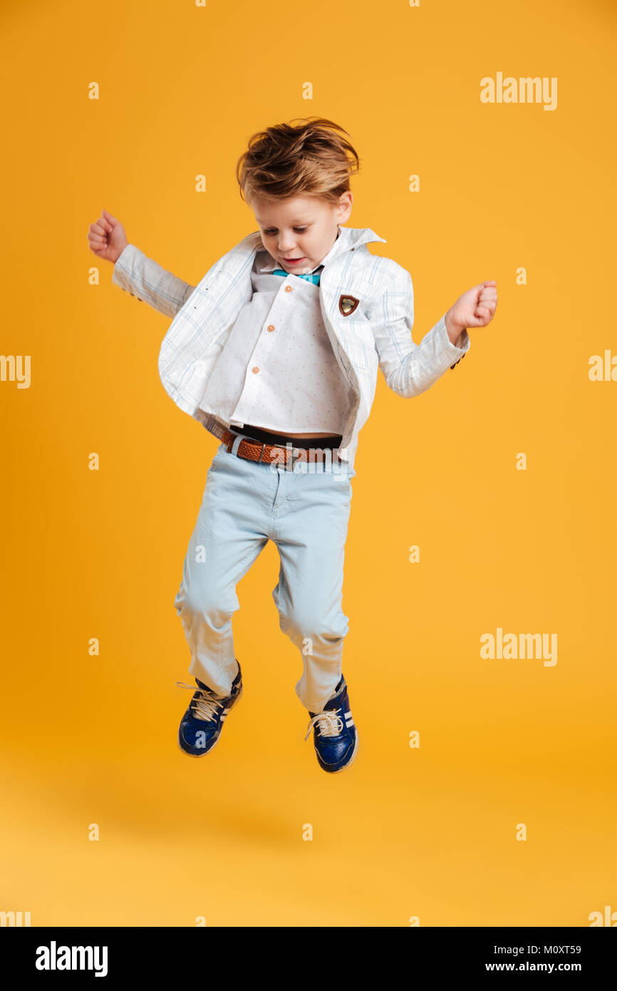 Image of little boy child jumping isolated over yellow background ...