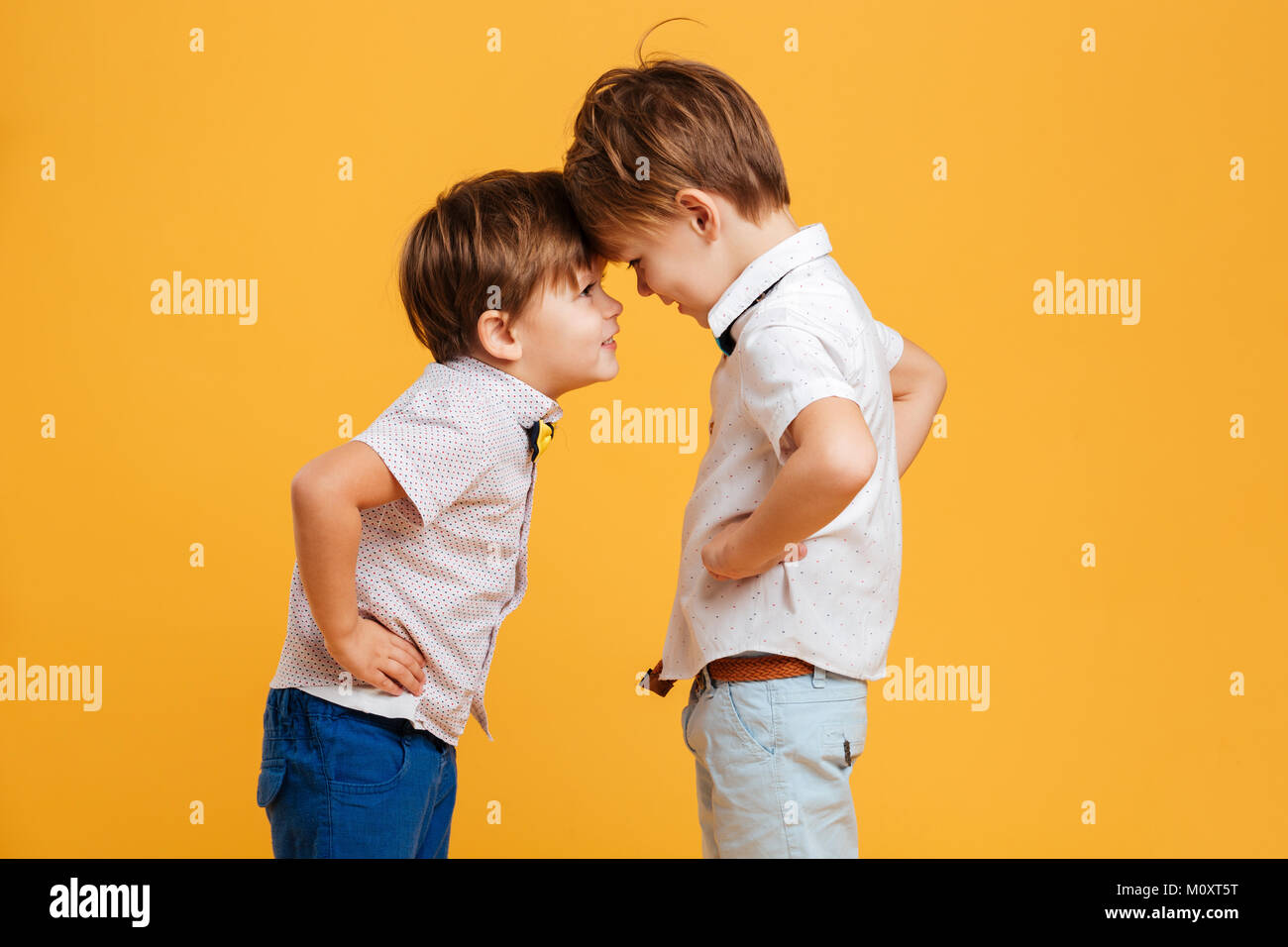 Photo of two funny little children brothers isolated over yellow ...