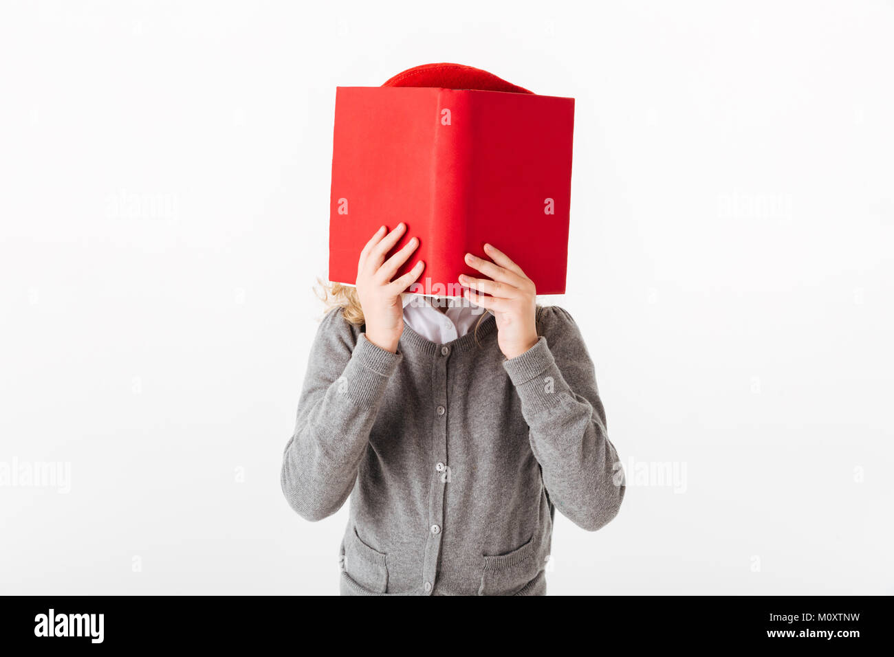 Child covering face with book hi-res stock photography and images - Alamy