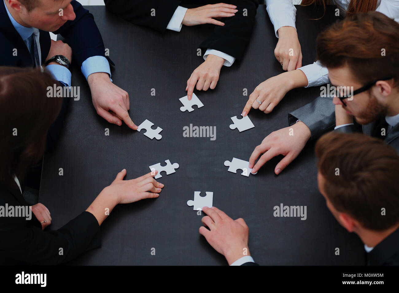 business team solving puzzle together Stock Photo - Alamy