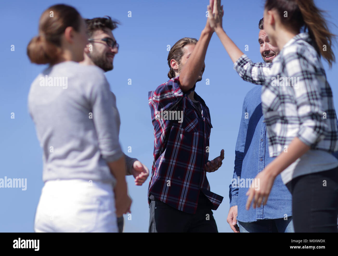 friends greet each other, giving a high five Stock Photo - Alamy