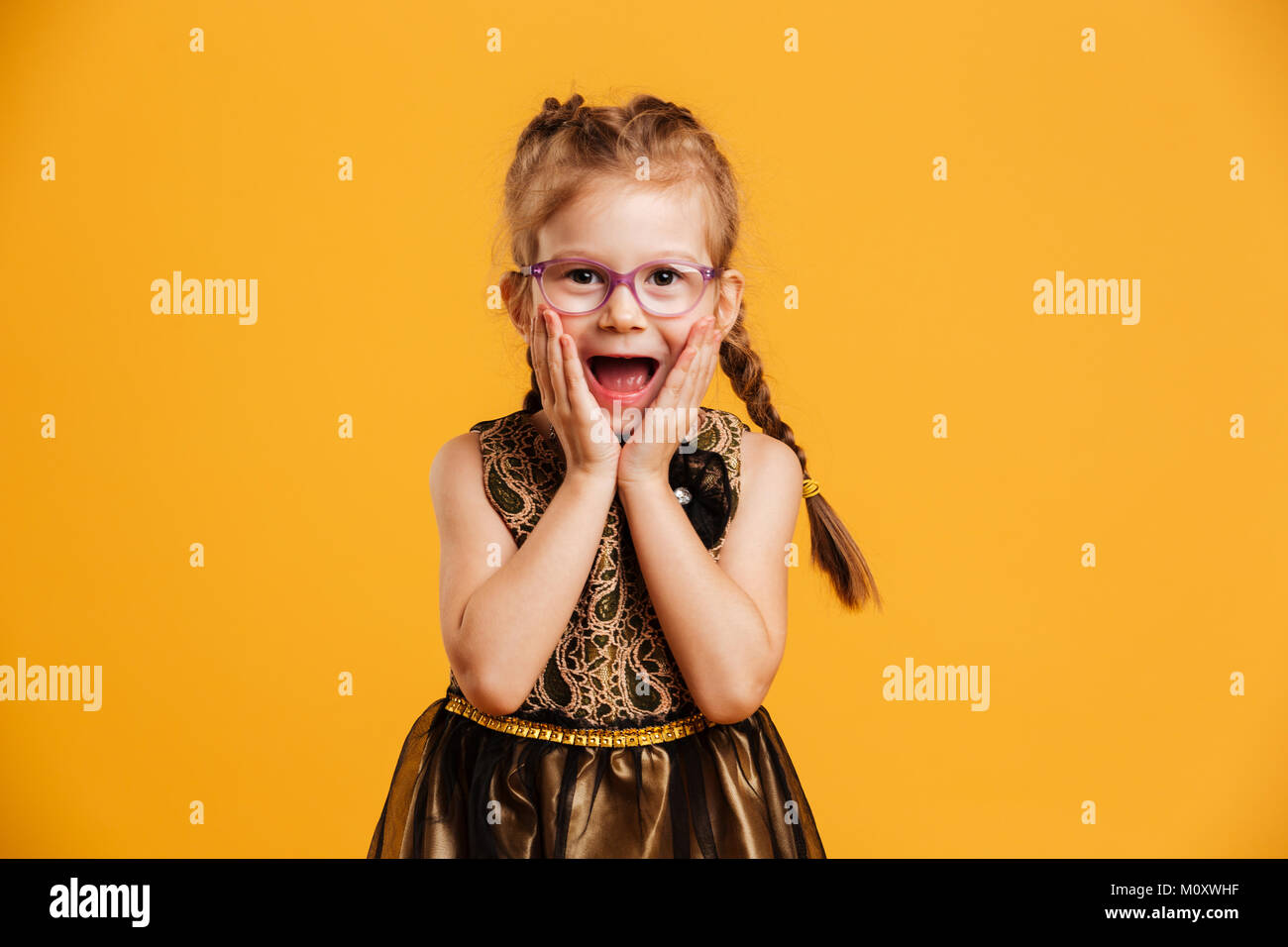 Photo of shocked little girl child standing isolated over yellow ...