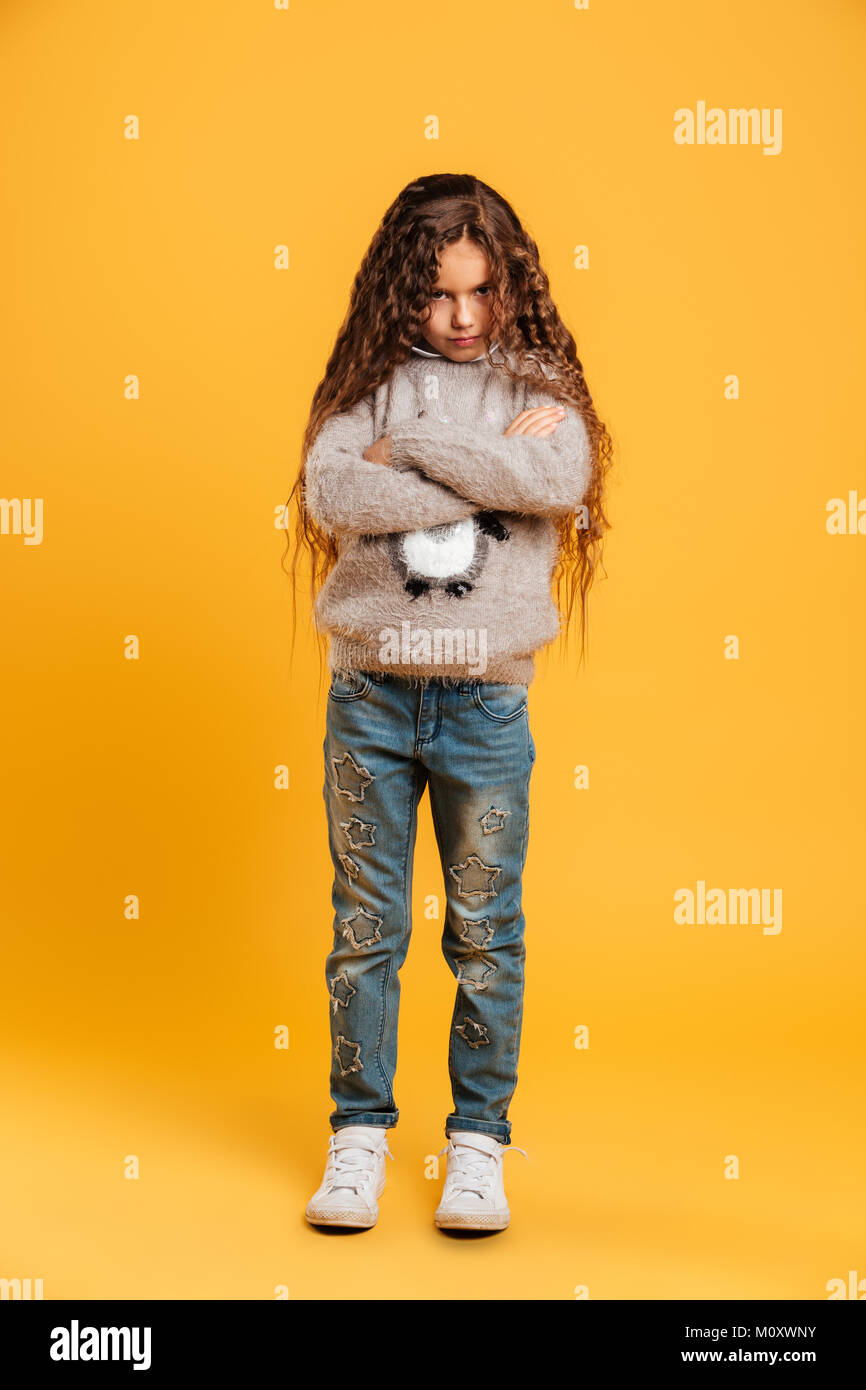 Picture of angry little girl child standing isolated over yellow ...