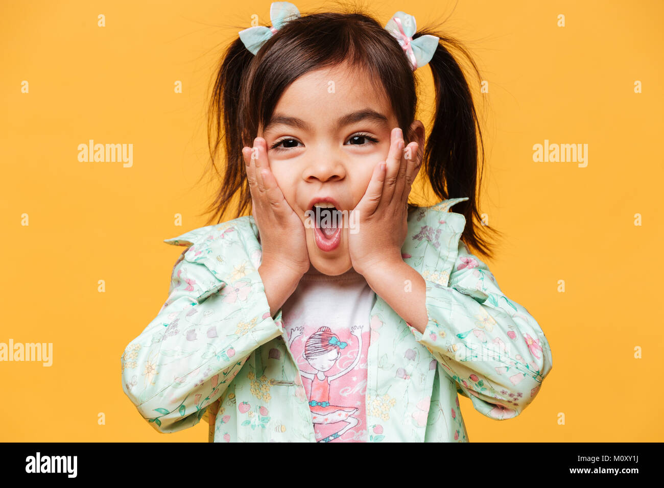 Image of shocked little girl child standing isolated over yellow ...