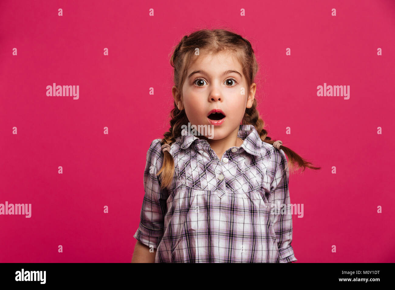 Picture of shocked little girl child standing isolated over pink ...