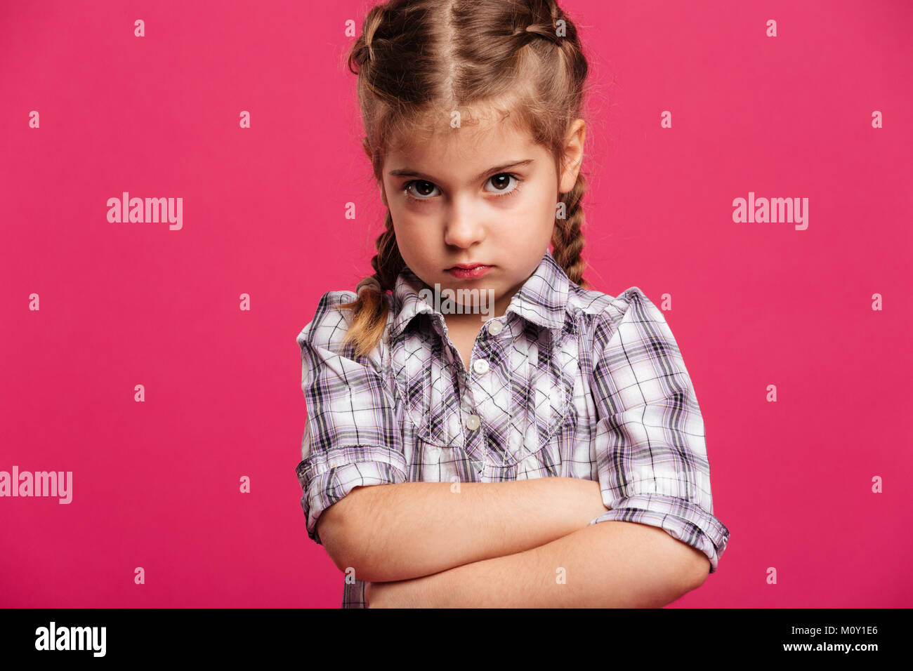 Photo of angry little girl child standing isolated over pink background ...