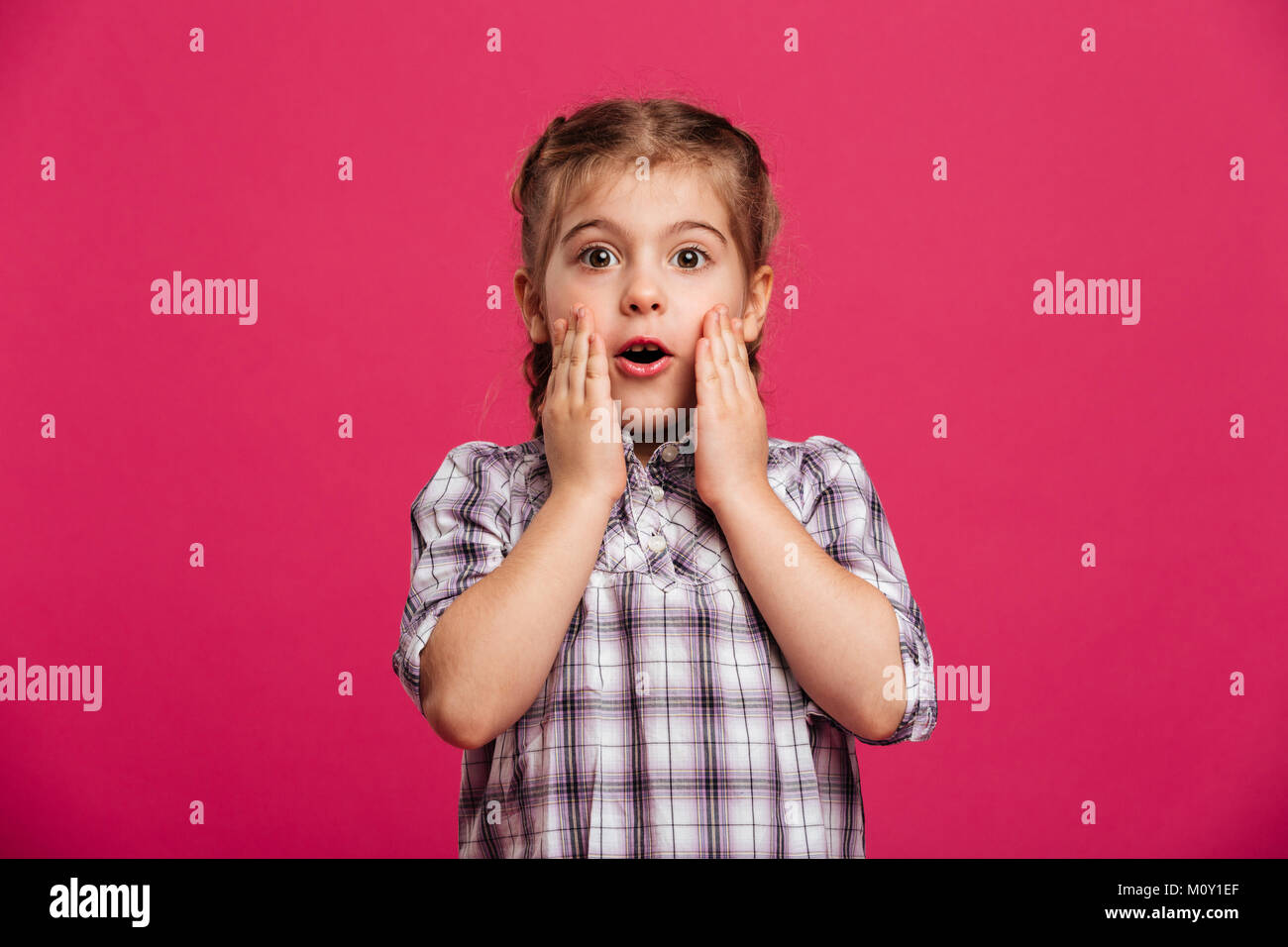 Photo of shocked cute little girl child standing isolated over pink ...