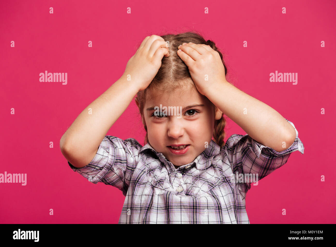 Picture of confused cute little girl child standing isolated over pink ...