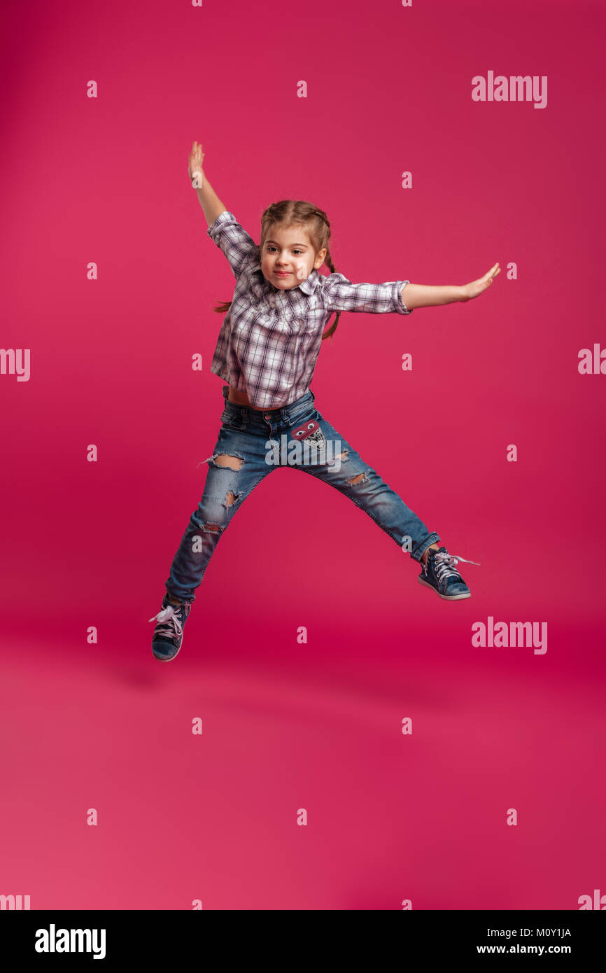 Image of little girl child jumping isolated over pink background ...