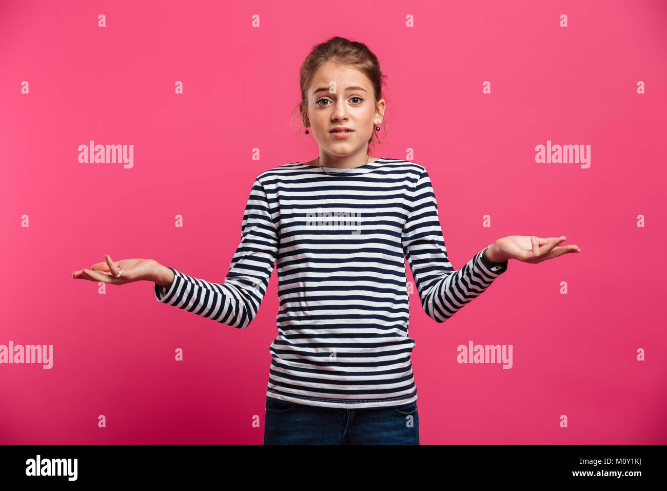 Photo of confused teenage girl standing isolated over pink background ...