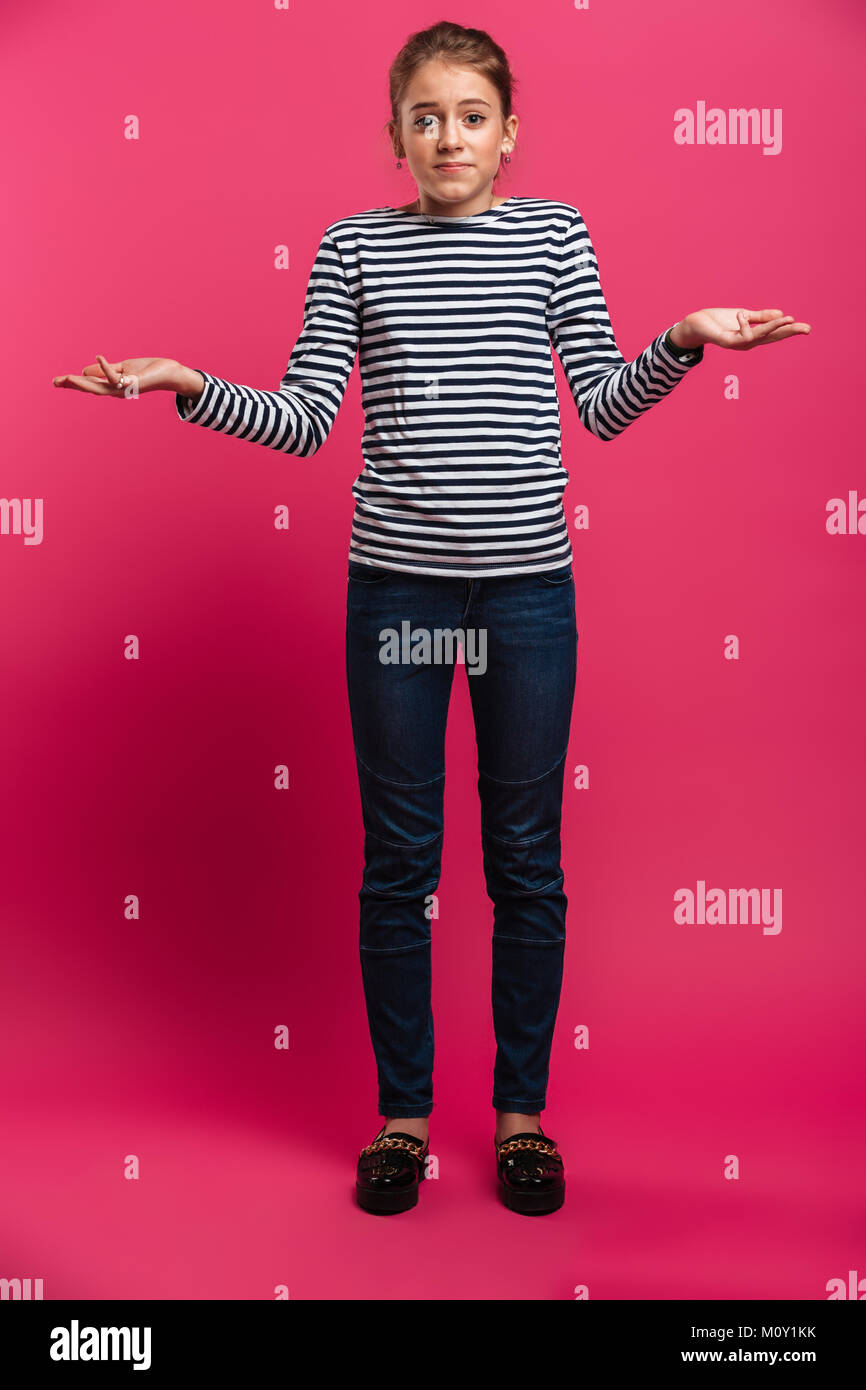 Photo of confused teenage girl standing isolated over pink background ...