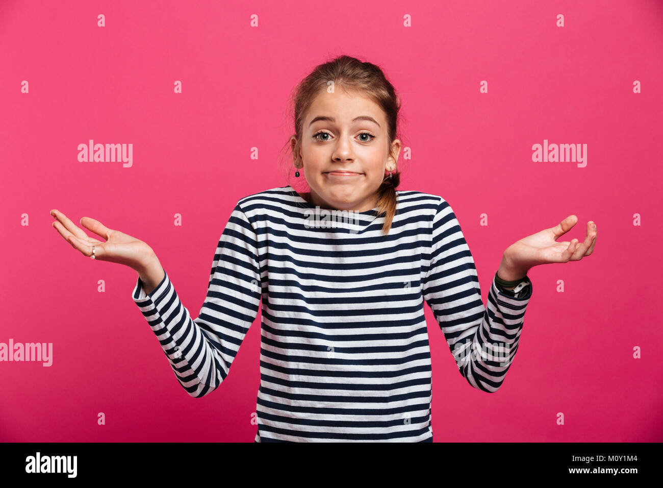 Photo of confused teenage girl standing isolated over pink background ...