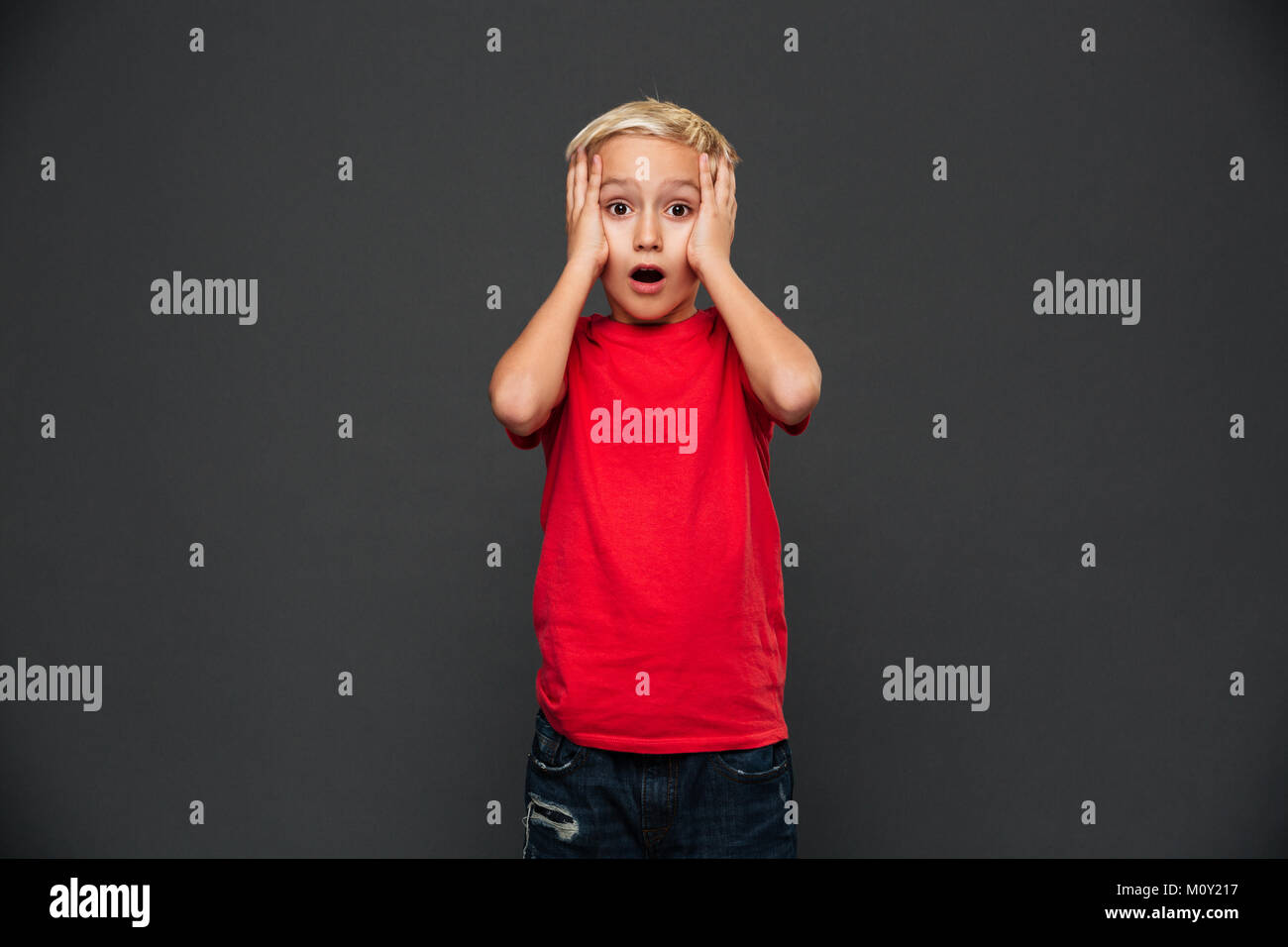 Picture of shocked little boy child standing isolated over grey ...