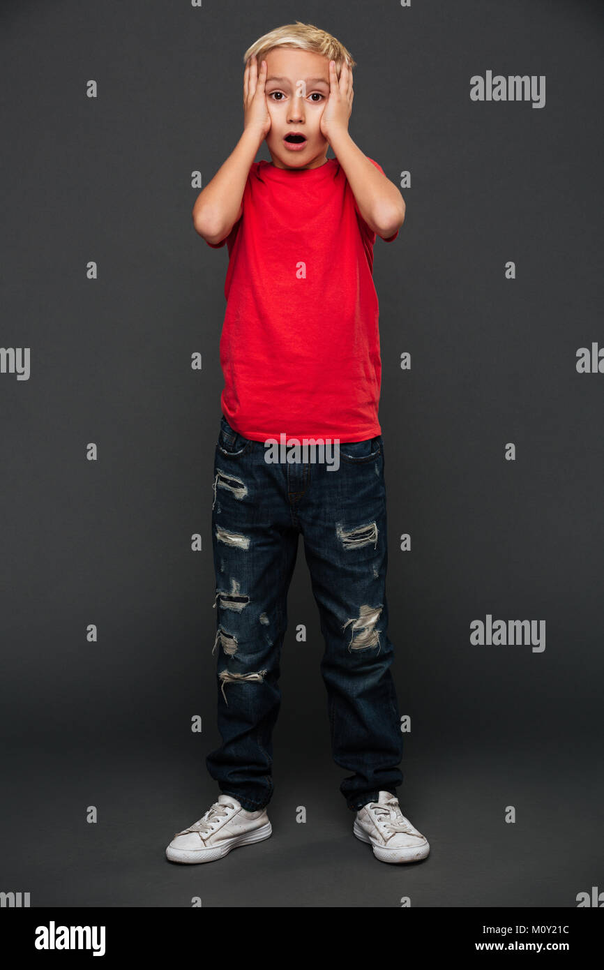 Picture of shocked little boy child standing isolated over grey ...