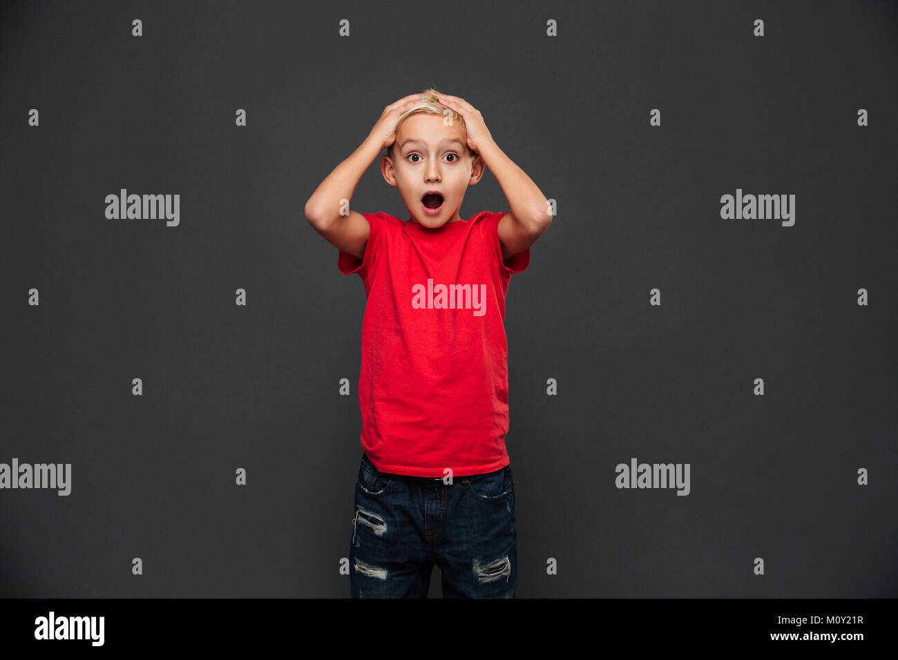 Picture of shocked little boy child standing isolated over grey ...