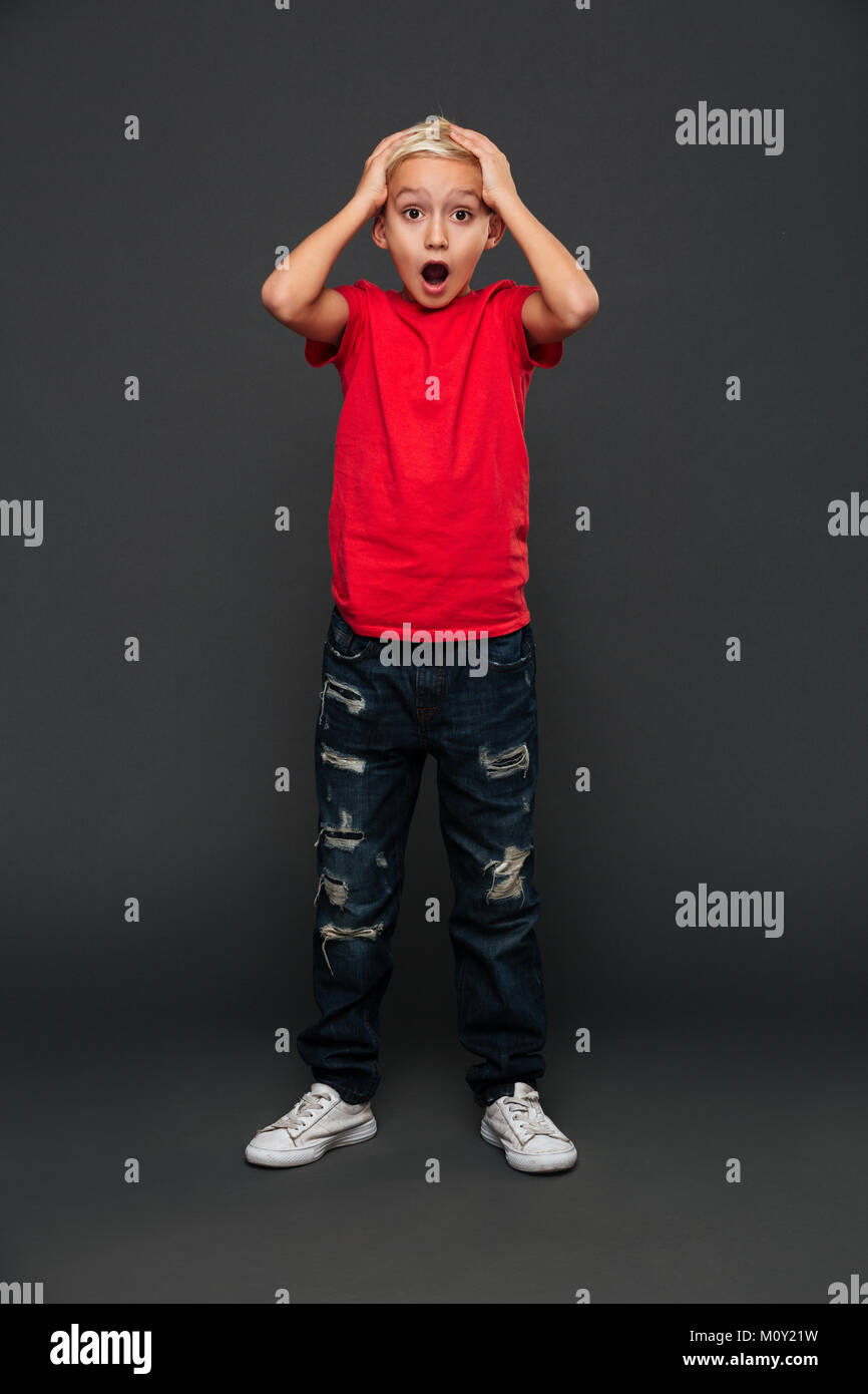 Picture of shocked little boy child standing isolated over grey ...