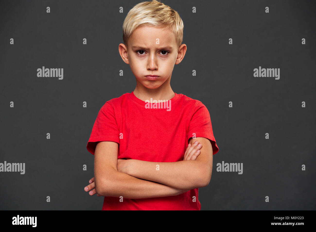 Photo of angry little boy child standing isolated over grey background ...