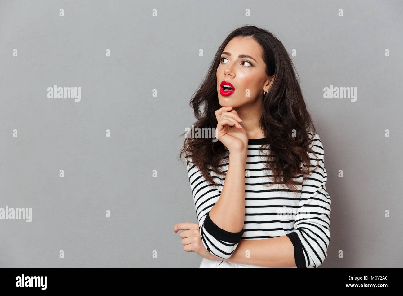 Portrait of a prety girl looking away at copy space isolated over gray ...