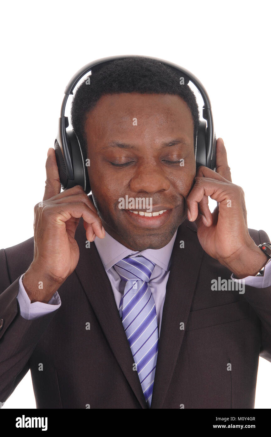 A happy looking African American business man with his headphones on ...