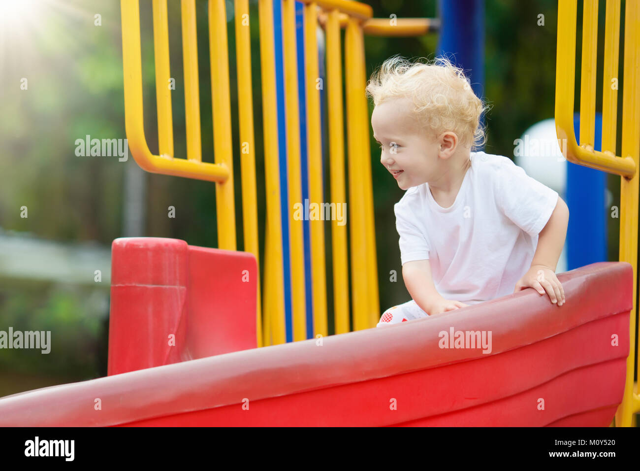 Kids on climbing and sliding on outdoor playground. Children play in ...